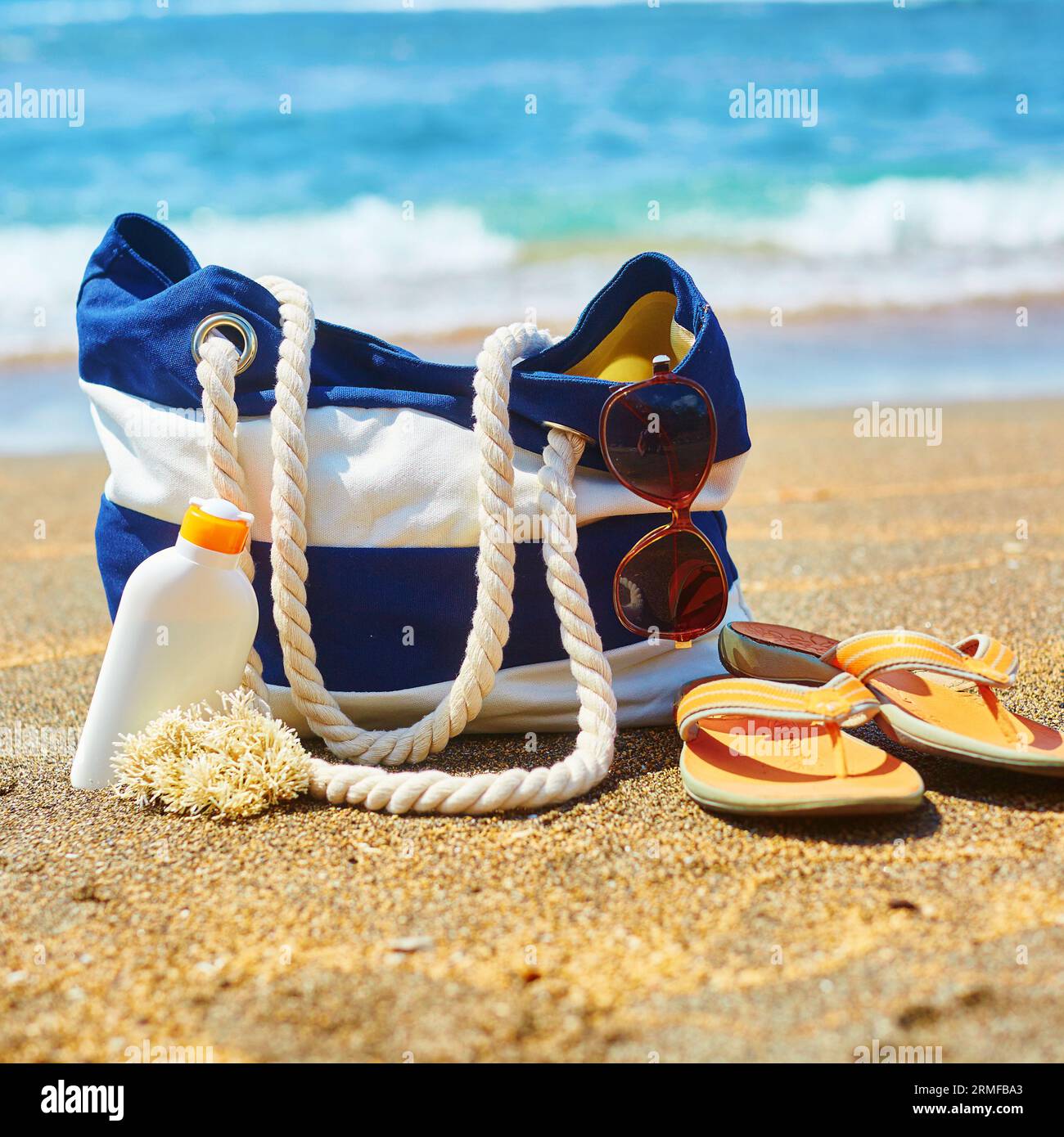 Beach bag, flip flops, sunscreen bottle and sunglasses on a Balinese ...