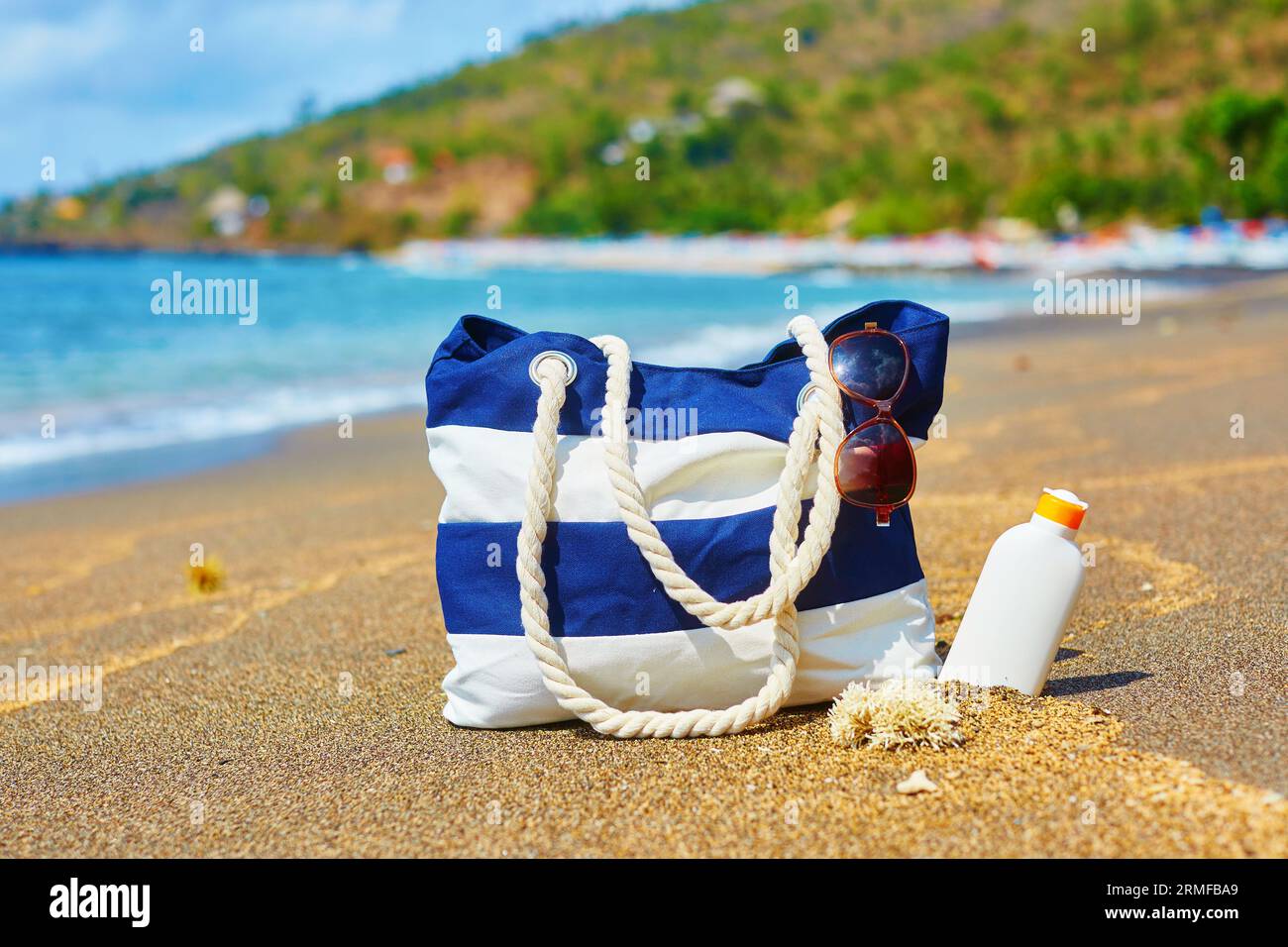 Beach bag, sunscreen bottle and sunglasses on a Balinese beach Stock ...