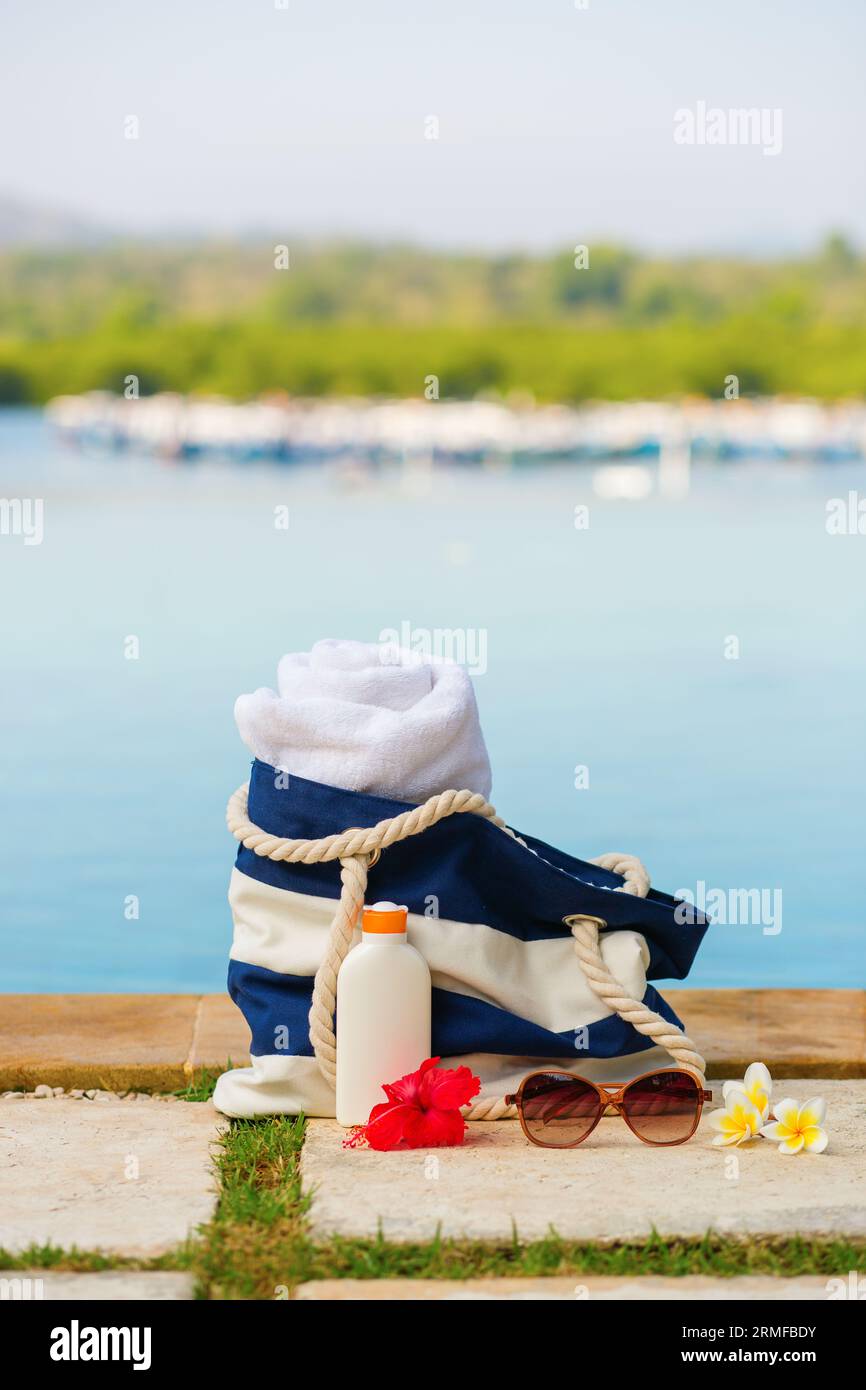 Beach bag, towel, sunscreen and sunglasses near the pool Stock Photo ...