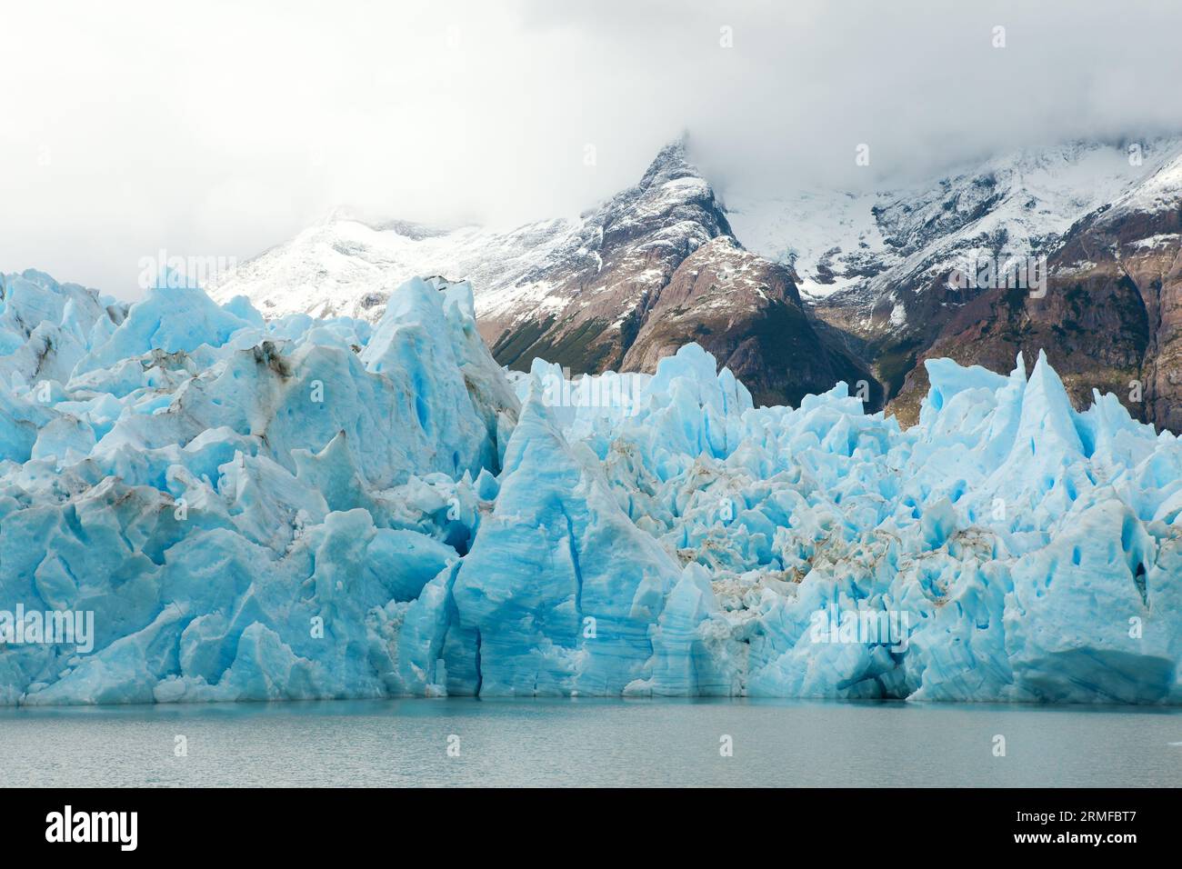 Blue icebergs and snowy mountains at Grey Glacier in Torres del Paine ...