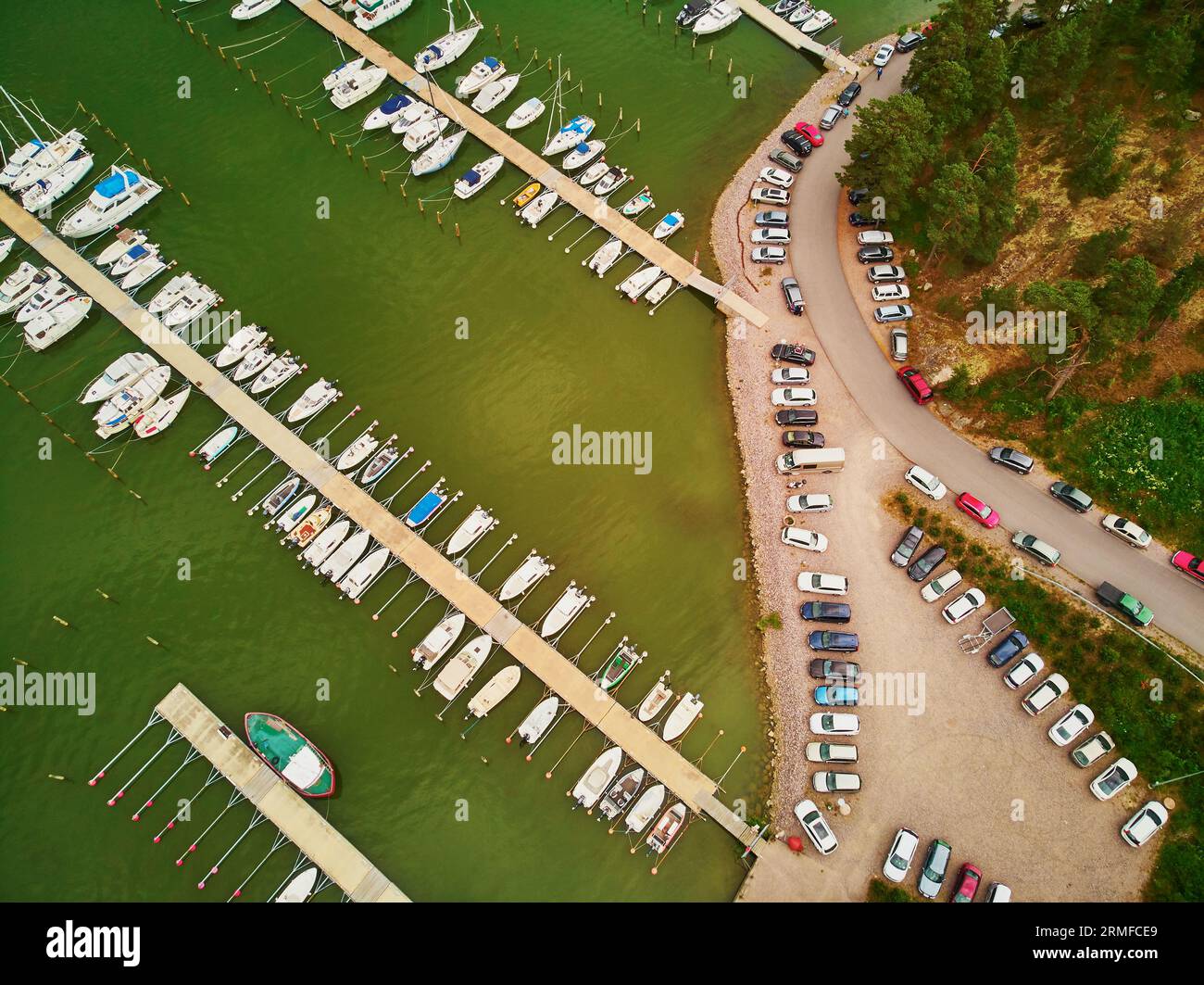 Scenic top down view of colorful boats near wooden berth and large car ...