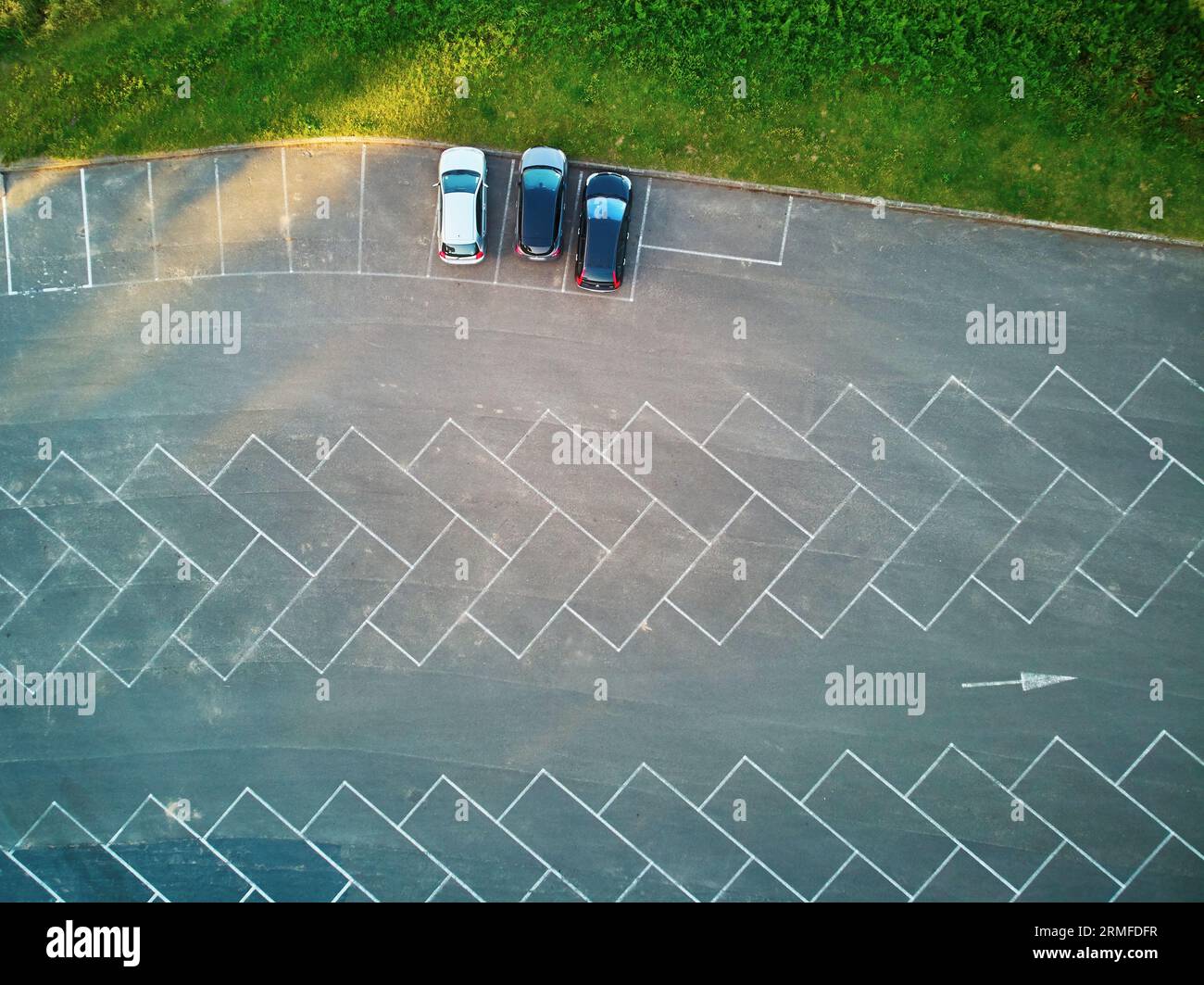 Aerial view of outdoor public parking lot with three cars parked on it ...