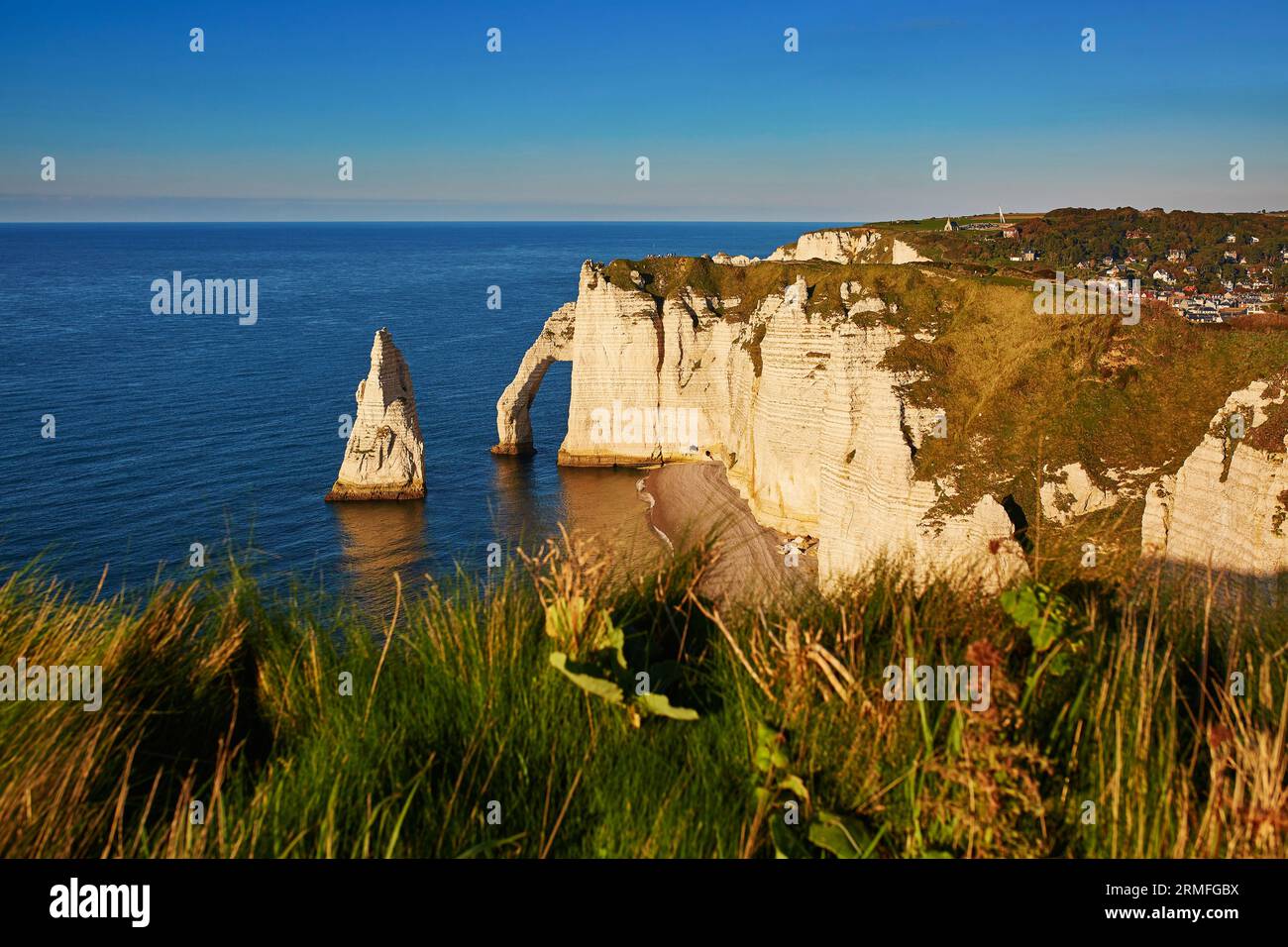 Scenic view of Etretat with its beach and famous cliffs with arches in ...