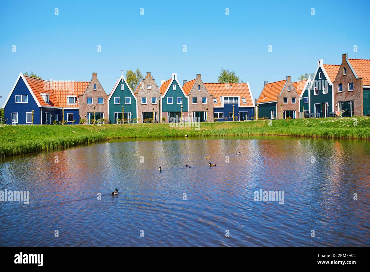 Colorful houses reflected in water in marine park in Volendam. Typical ...