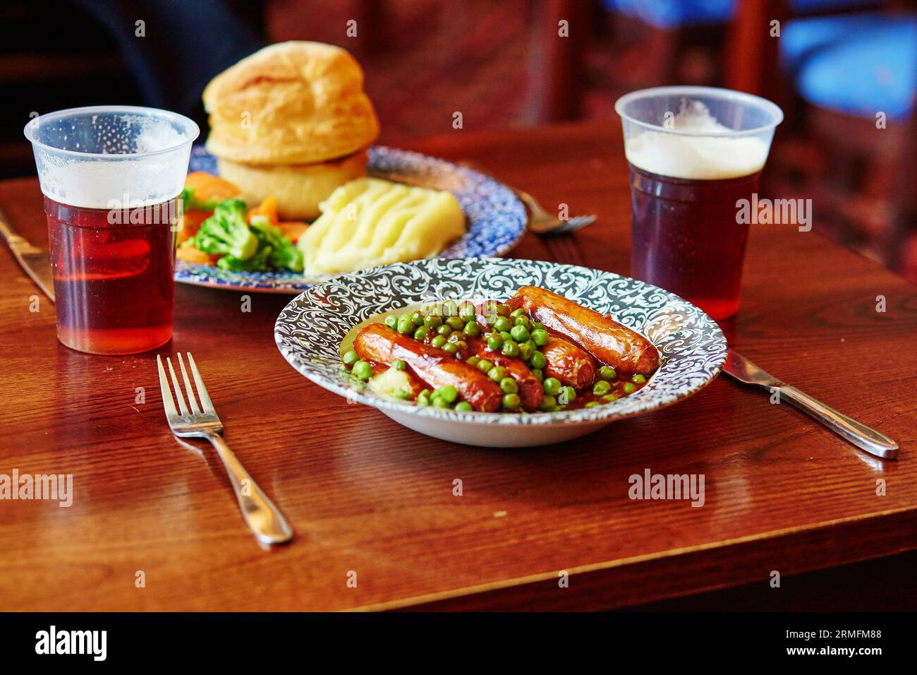 Pork sausages, mashed potatoes, green peas and onion gravy with ale in ...