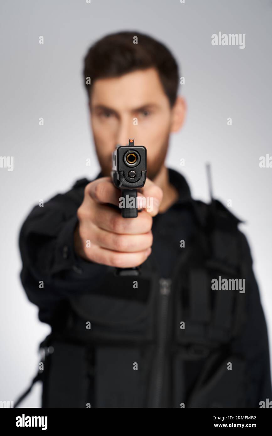 Armed caucasian police officer aiming with handgun to camera. Selective ...
