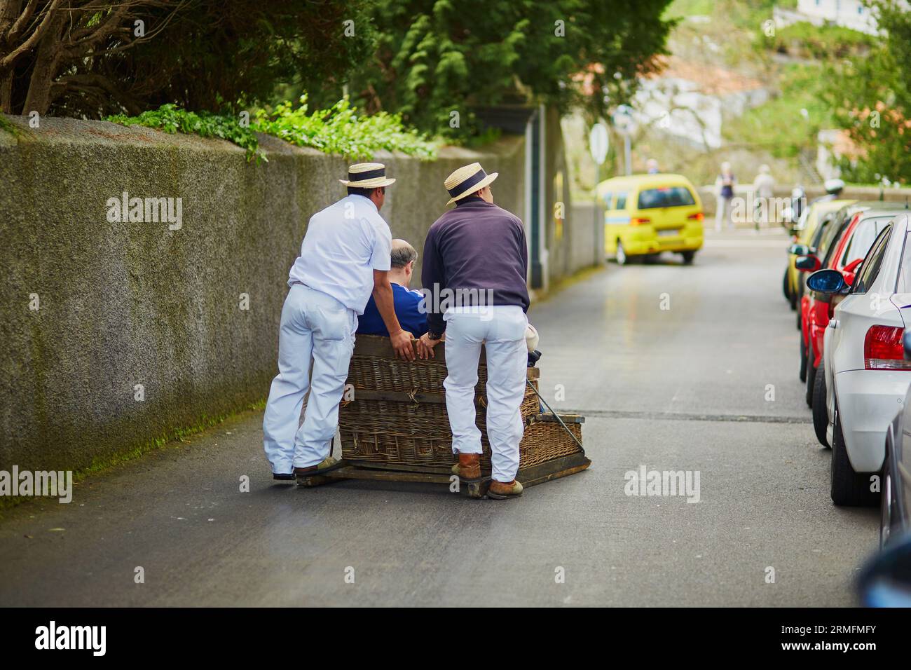 Famous toboggan riders moving traditional cane sledge downhill on the ...