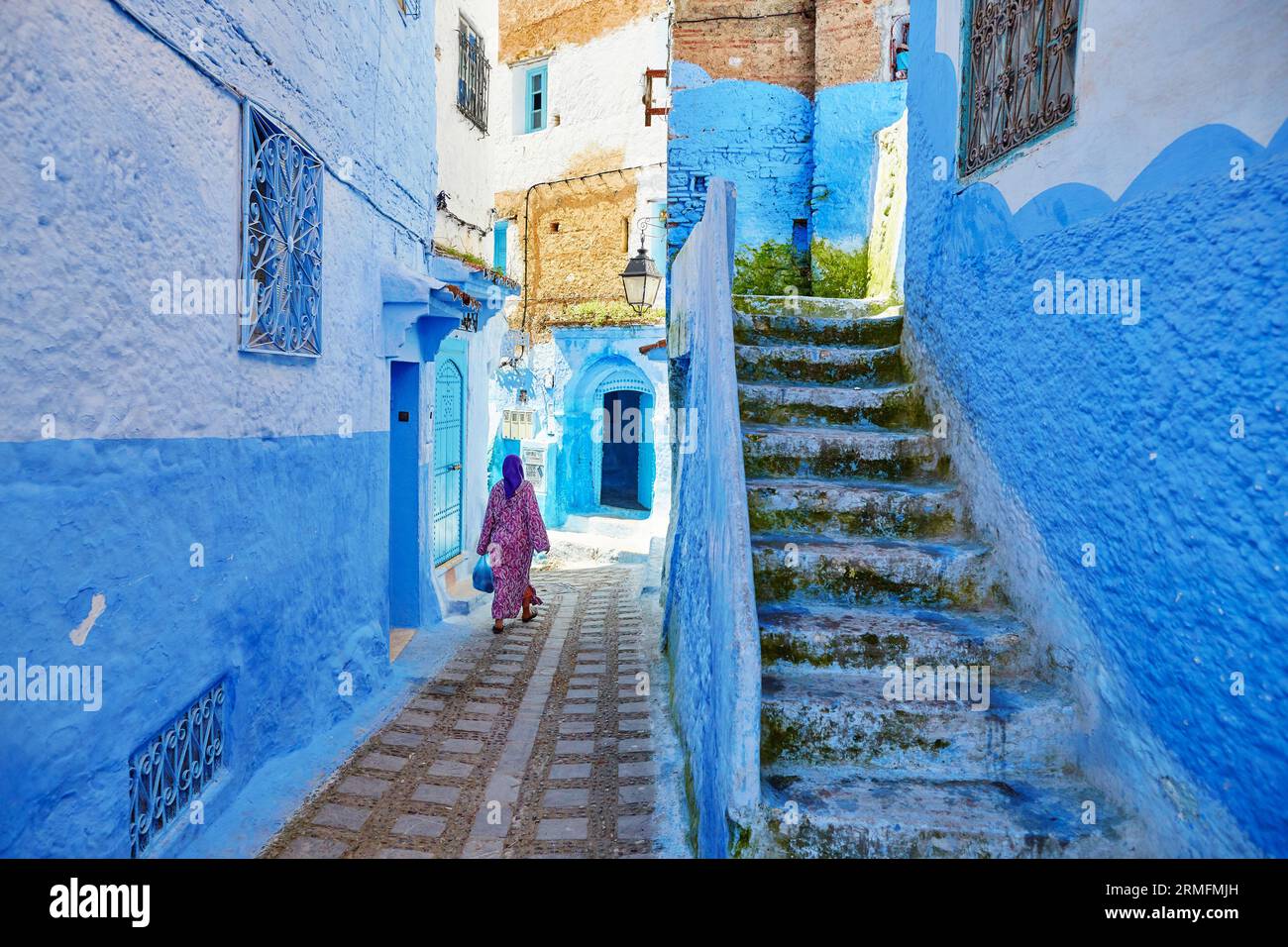 Moroccan woman in traditional clothes (jellaba) walking on a street in ...