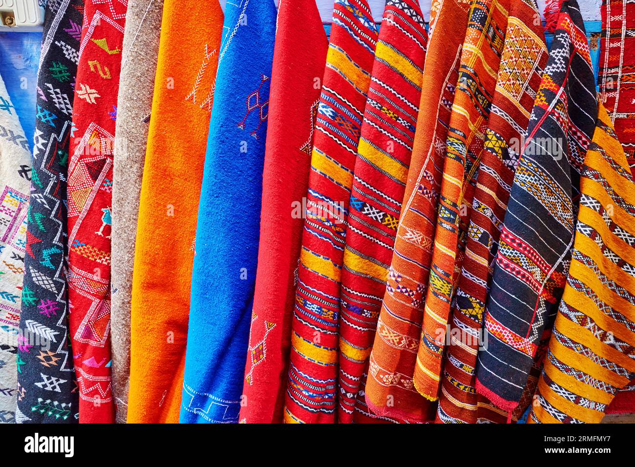 Colorful fabrics and carpets for sale on a street in Medina of ...