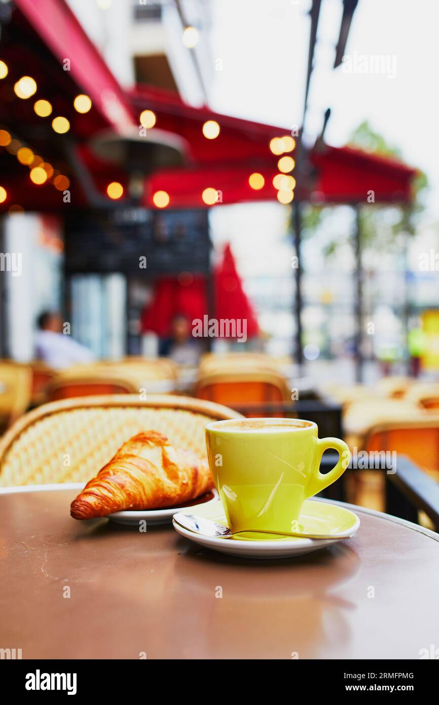 Cup of fresh hot coffee and traditional French croissant on table of ...