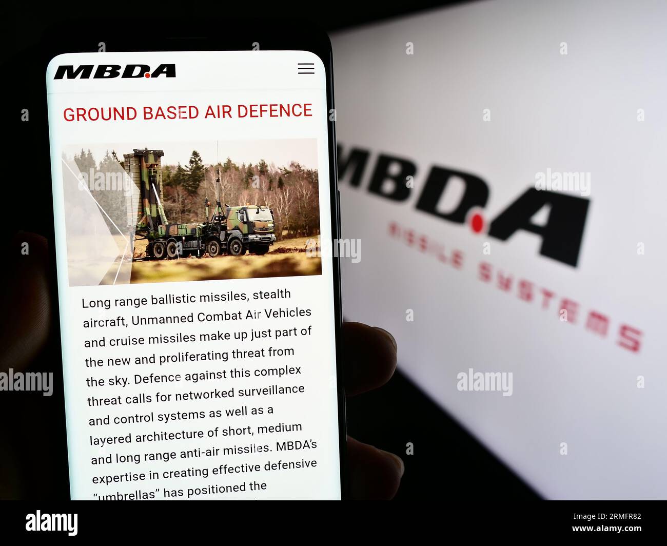 Person holding smartphone with web page of French missile systems ...