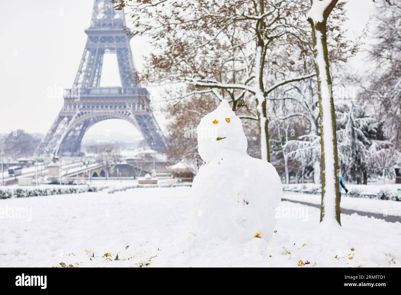 Funny snowman and the Eiffel tower on a day with heavy snow. Unusual ...