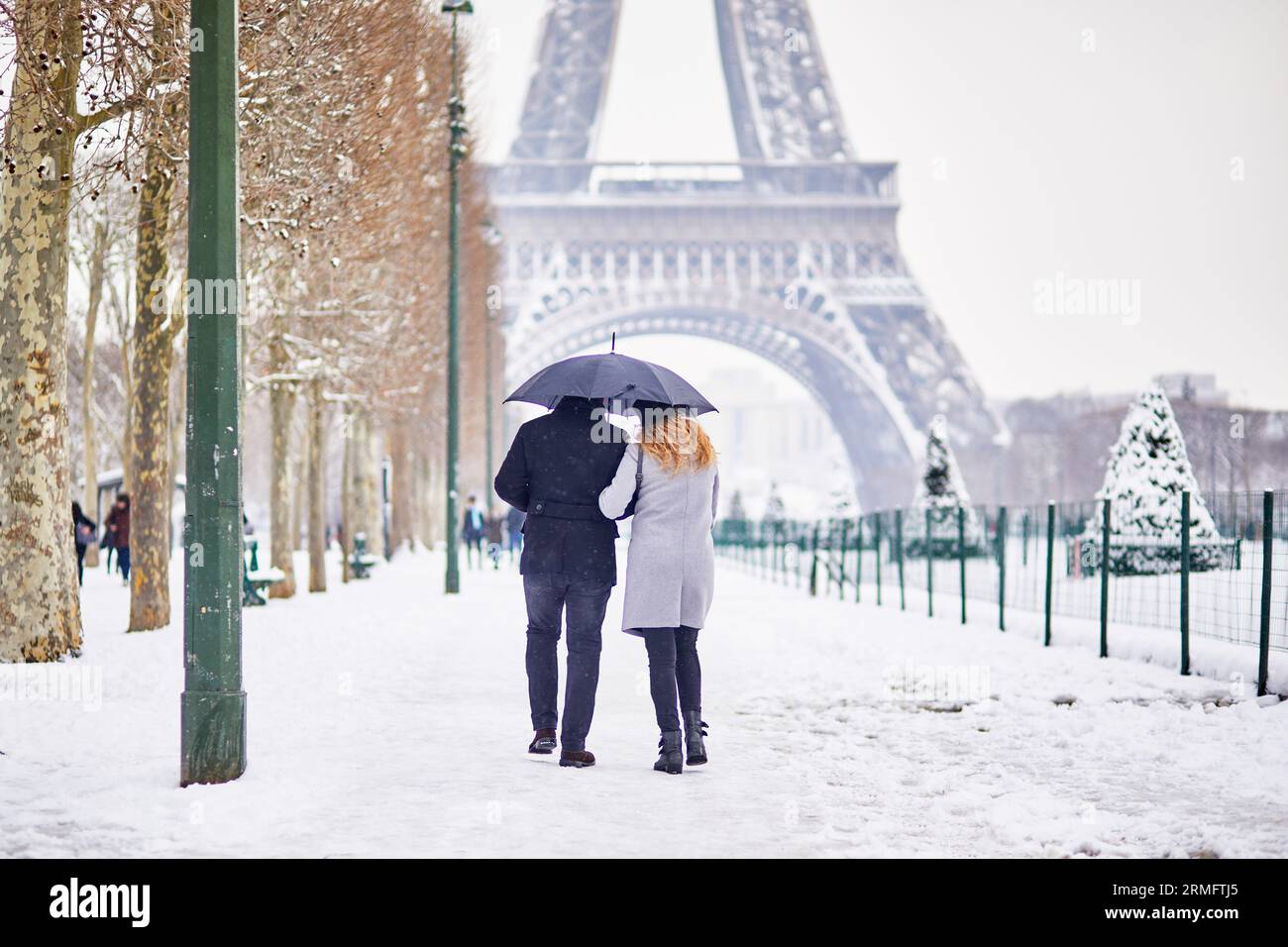Couple of tourists walking in Paris under umbrella on a day with heavy ...