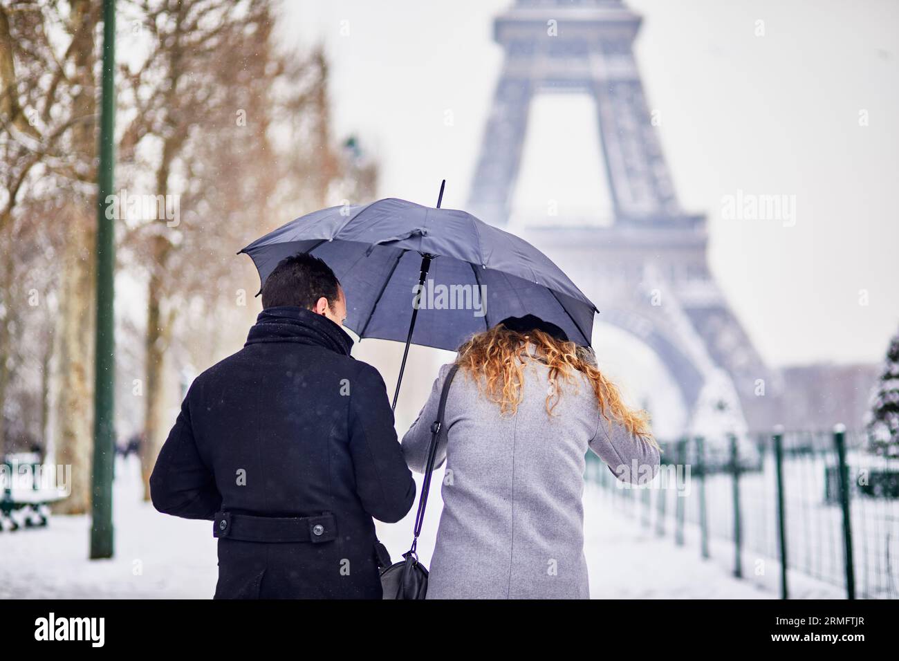 Couple of tourists walking in Paris under umbrella on a day with heavy ...