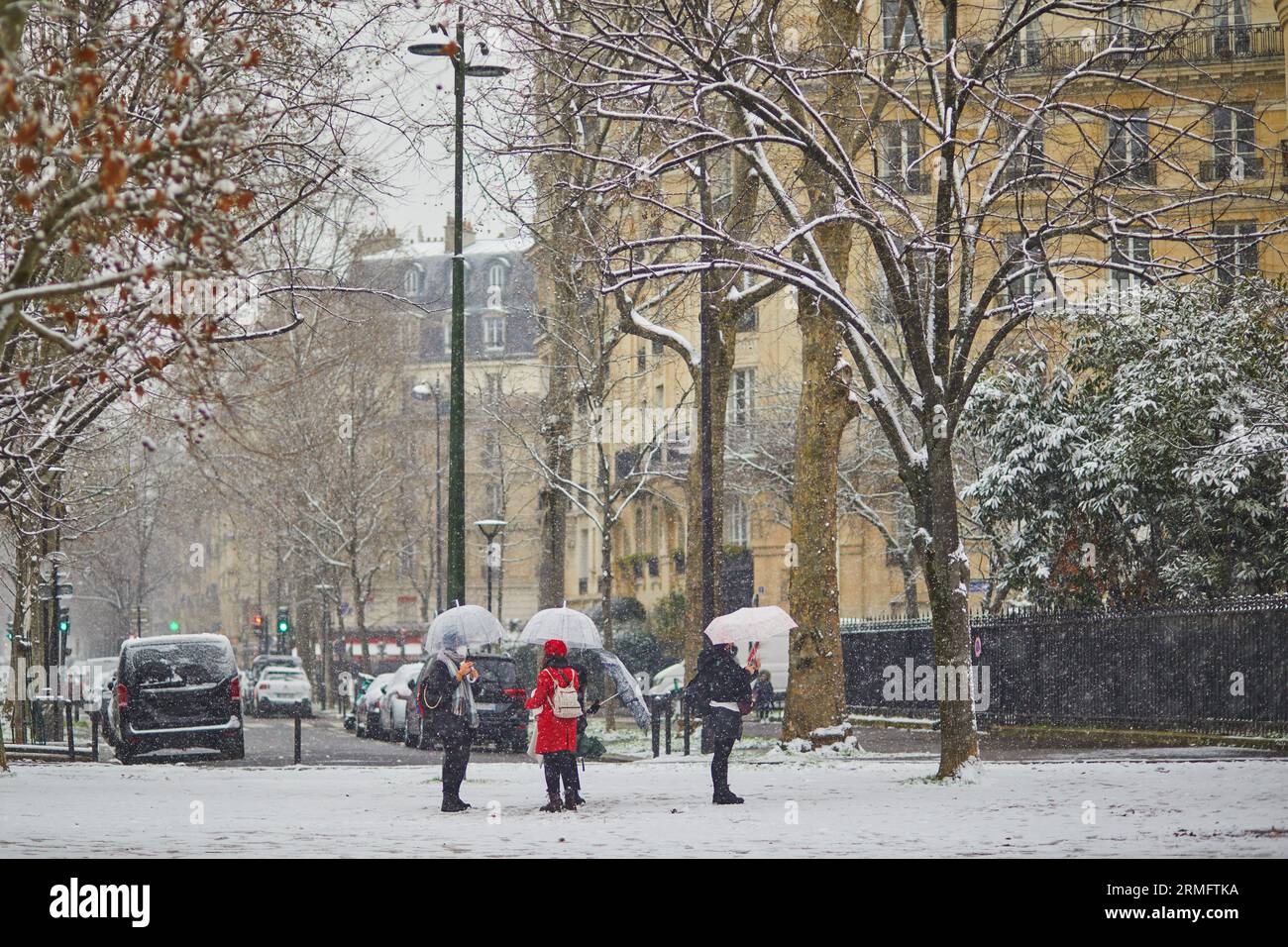 People passing by the Eiffel tower in Paris on a day with heavy snow ...