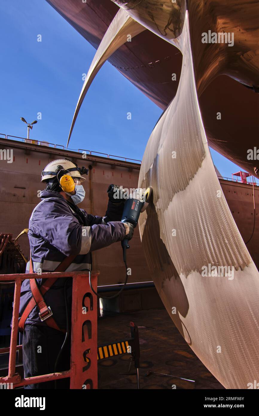 man repairing a ship propeller using a handheld saw .propeller ship ...