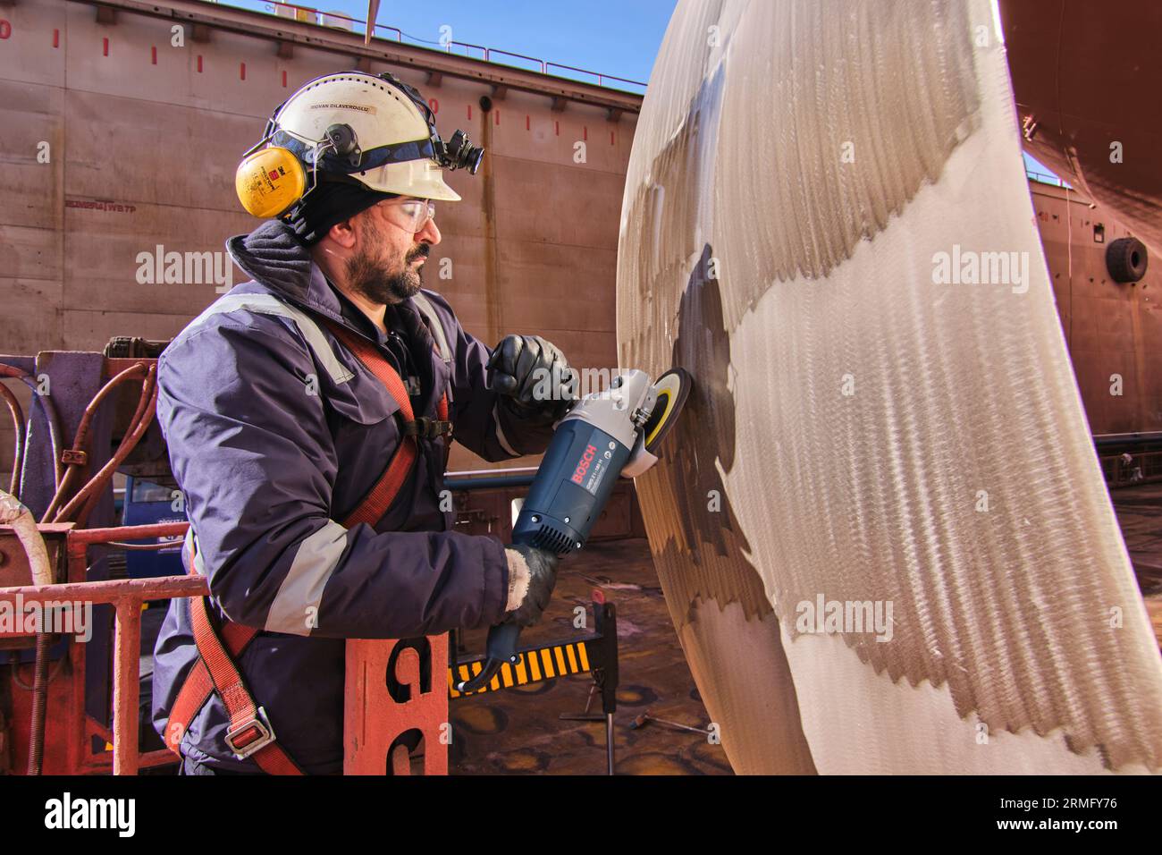 man repairing a ship propeller using a handheld saw .propeller ship ...