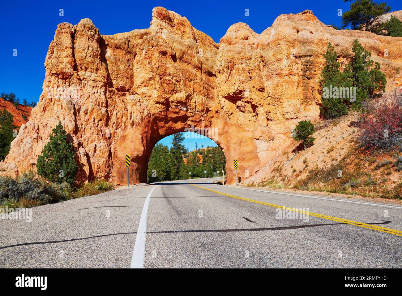Scenic view of stunning red sandstone natural bridge and asphalt road ...