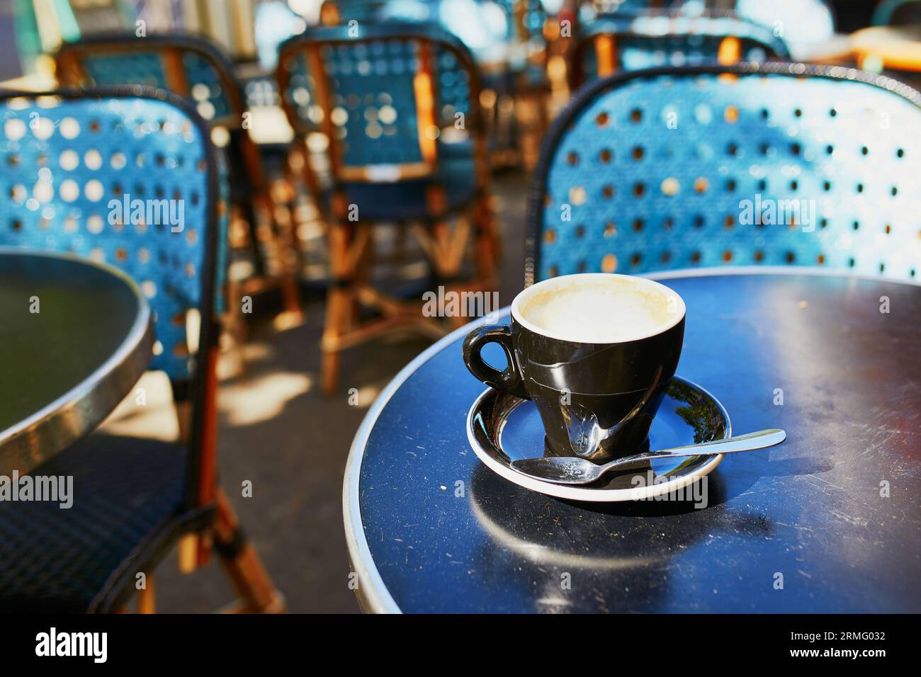 Cup of coffee on the table of traditional French street cafe in Paris ...