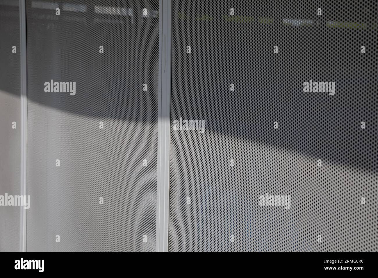 Perforated metal panel with round holes punctuated by a vertical strip ...