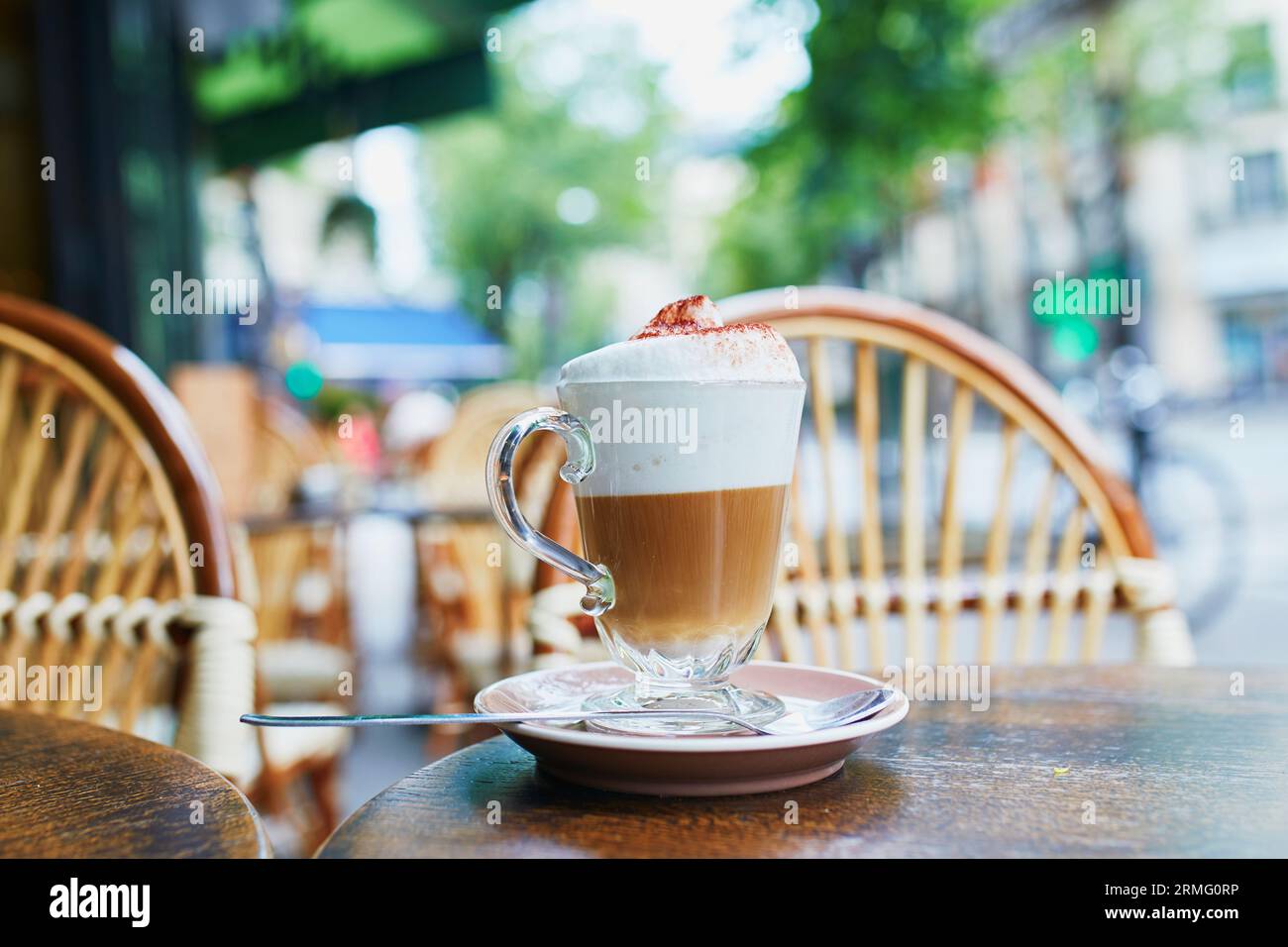 Cup of coffee on the table of traditional French street cafe in Paris ...