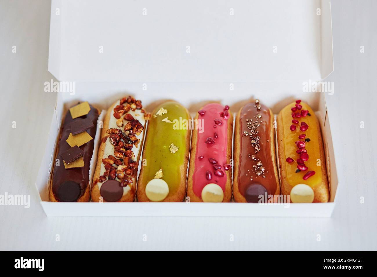 Various colorful French eclairs in the box Stock Photo - Alamy