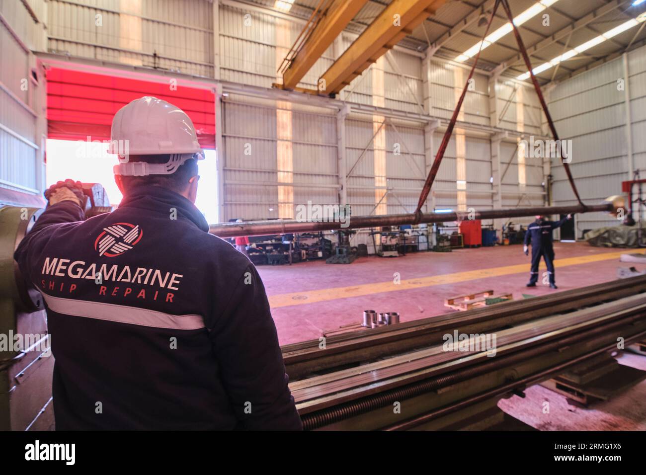 men using a lift and a crane to move big, heavy metal objects like pips ...