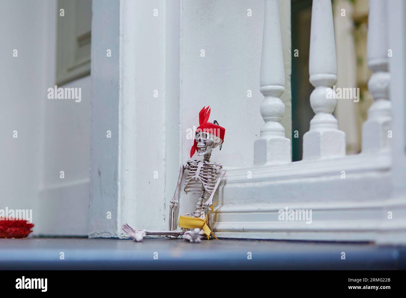 Skeleton as Halloween decoration, sitting on the porch of a building ...