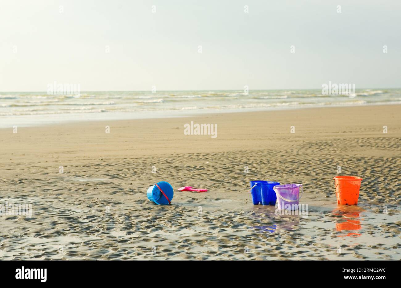 Colorful children's buckets for playing on the beach Stock Photo - Alamy