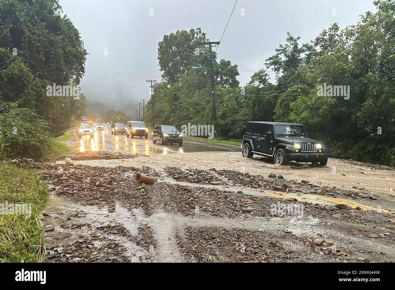 Vehicles maneuver around a mudslide caused by heavy rains along U.S ...