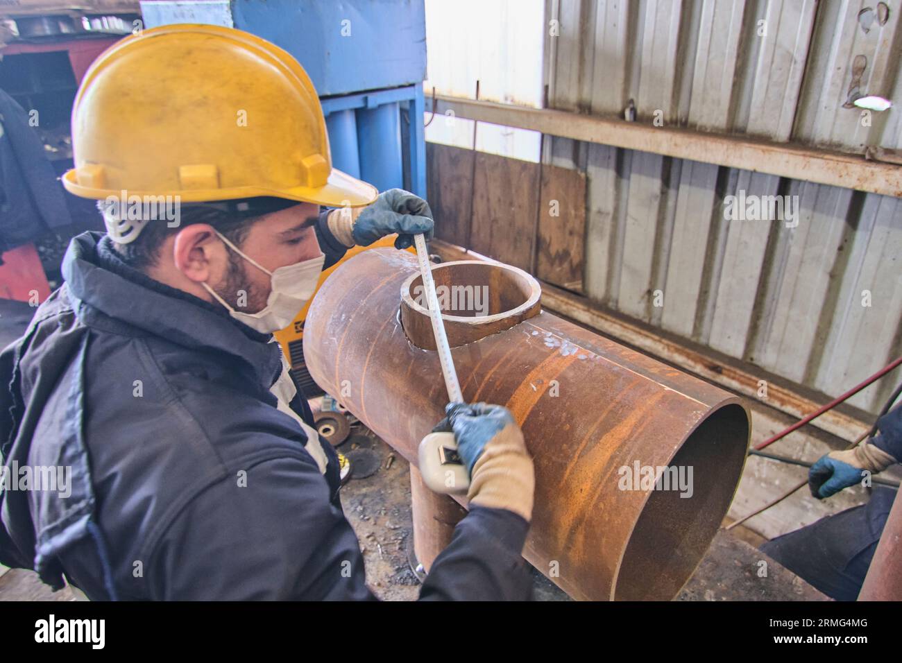 worker does measurement of diameter of a pipe. man doing measurement on ...
