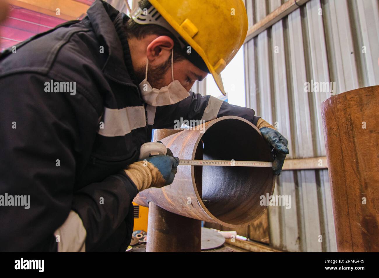 worker does measurement of diameter of a pipe. man doing measurement on ...