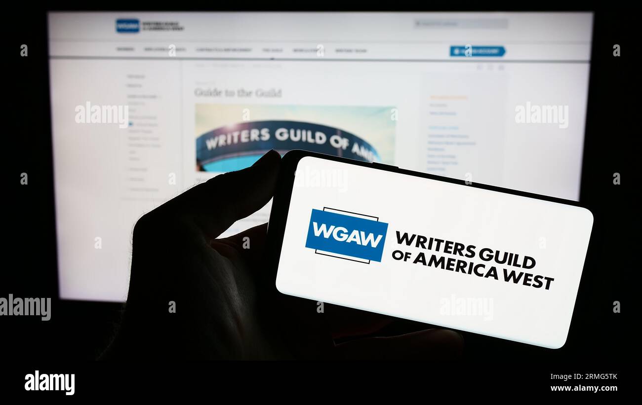 Person holding cellphone with logo of labor union Writers Guild of ...