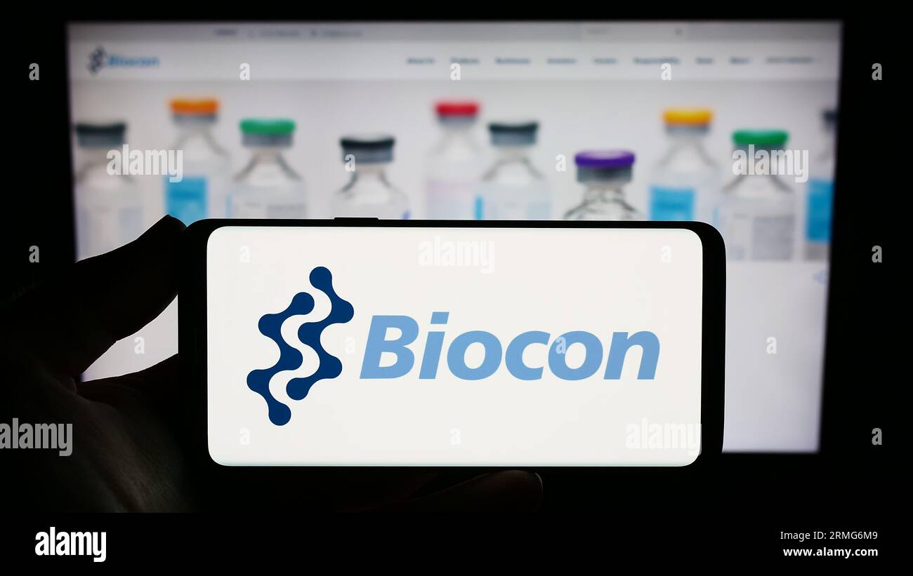 Person holding smartphone with logo of Indian biopharmaceutical company ...