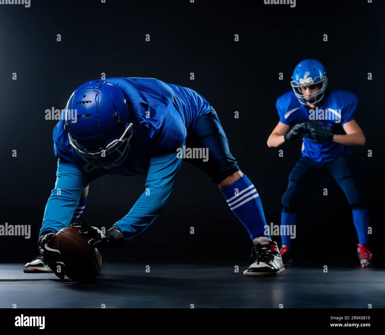 Two American football players are ready to start the game on a black ...