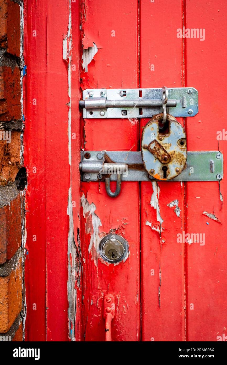 Closed padlocked and bolted red rustic door. Concept security, closed ...
