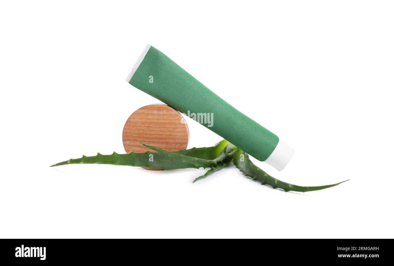 Tube of toothpaste, aloe vera leaves and wooden decor on white ...