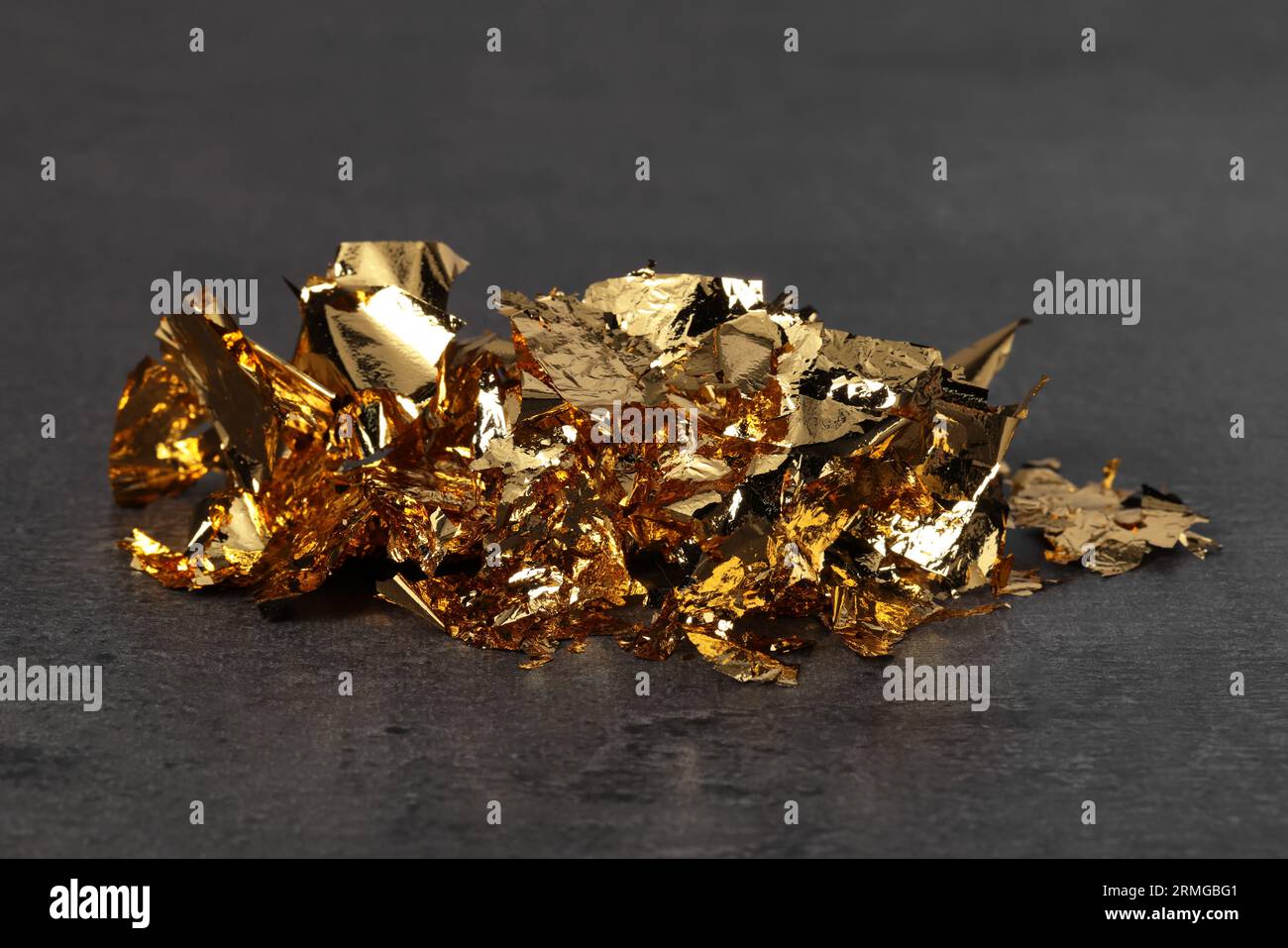 Pieces of edible gold leaf on textured table, closeup Stock Photo - Alamy