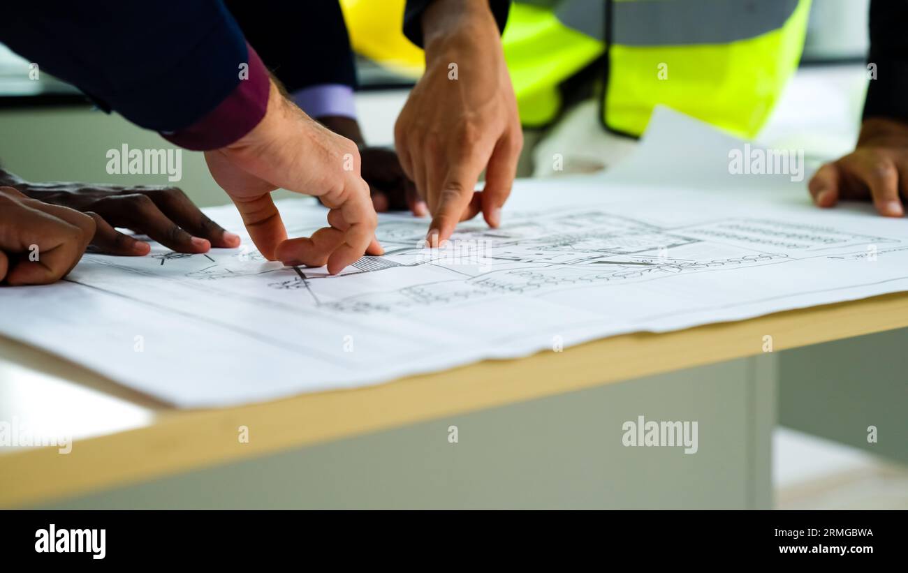 Construction engineers team using blueprint of project plan ...