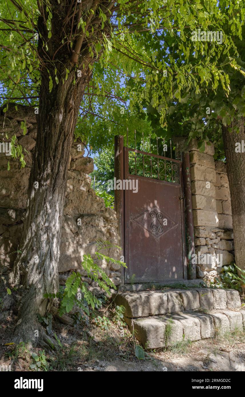 Olg gate in stone ruins wall in the traditional village of Butuceni ...