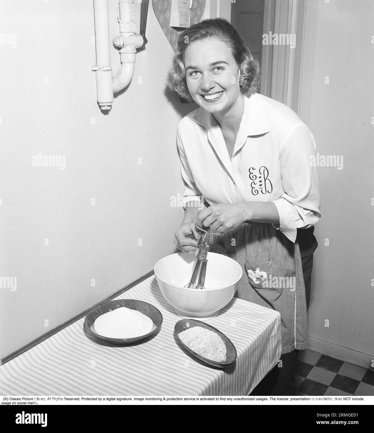 In the kitchen 1950s. Interior of a kitchen and a young woman that ...