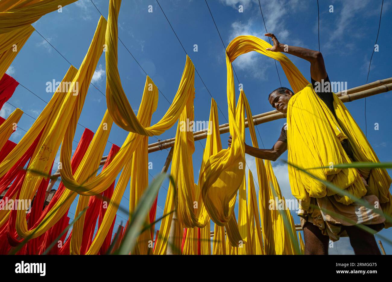 Dyed clothes of different colors are dried in the sun Stock Photo - Alamy