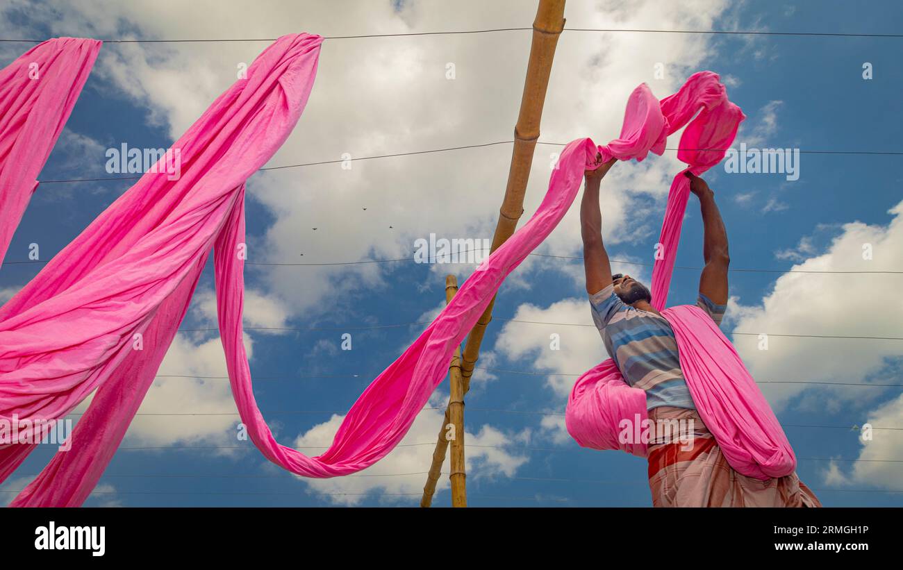 Dyed clothes of different colors are dried in the sun Stock Photo - Alamy