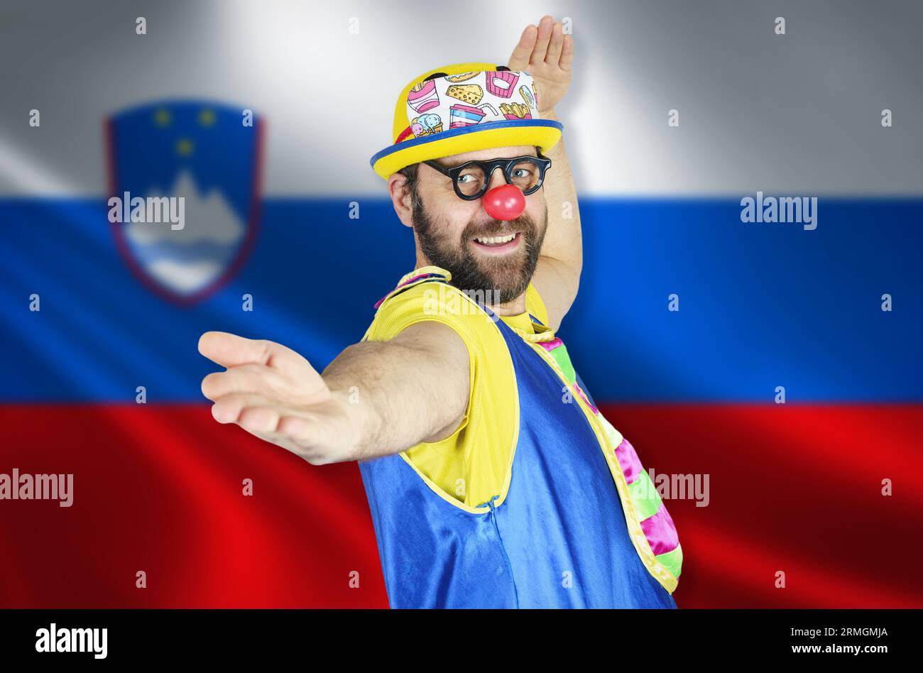 A cheerful clown stands in a welcoming pose against the background of ...
