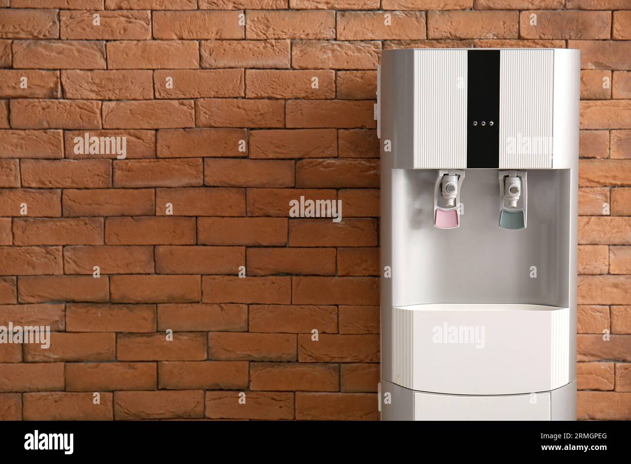 Modern water cooler on brick background Stock Photo - Alamy