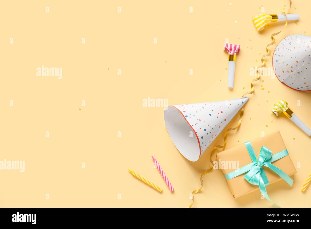 Different party decor on pale yellow background Stock Photo - Alamy