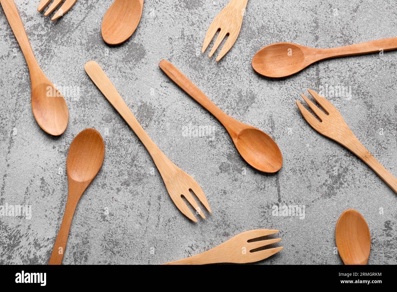 Wooden spoons and forks on grey background Stock Photo - Alamy
