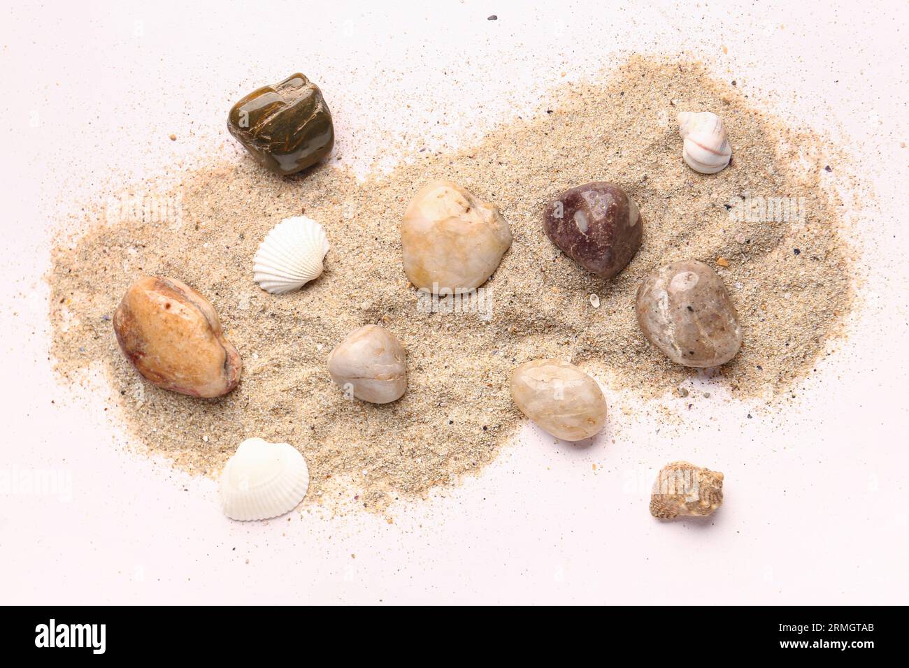 Pebble stones, seashells and sand on white background Stock Photo - Alamy