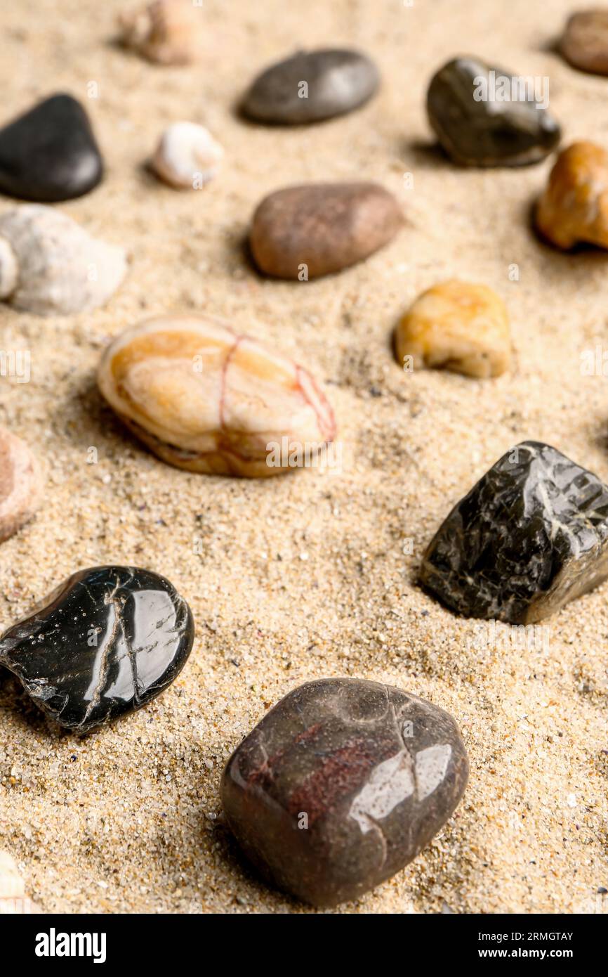 Many pebble stones on sand Stock Photo - Alamy