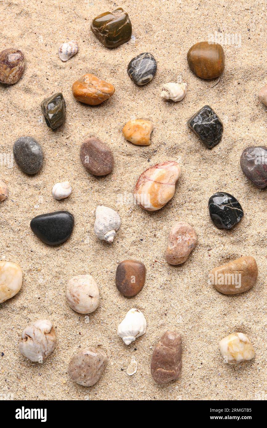 Many pebble stones on sand Stock Photo - Alamy
